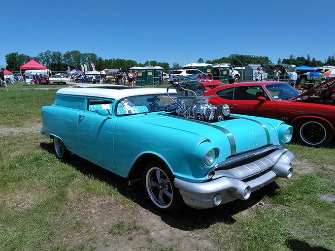 Classic car enthusiasts gather like pilgrims at a shrine. Each polished fender and chrome detail represents countless hours of passionate restoration,