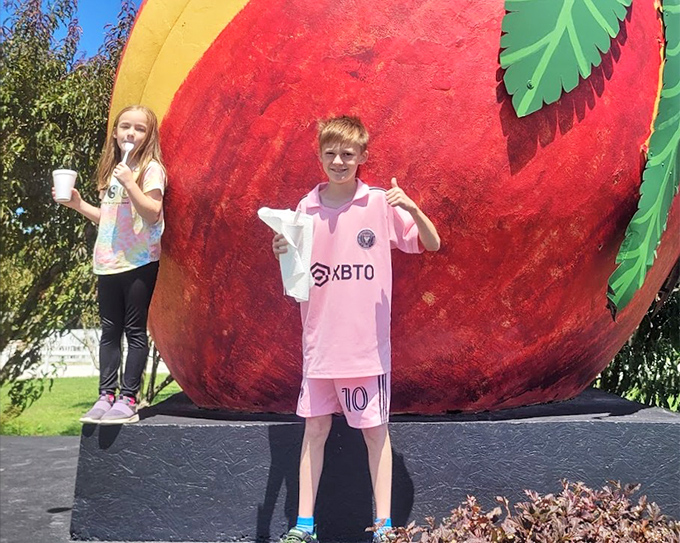 Young adventurers stake their claim on the monument's base, creating memories that will ripen sweetly with time.