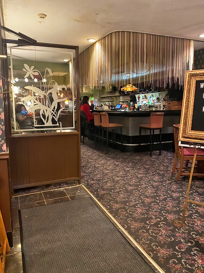 The entrance welcomes you with etched glass dividers and that distinctive floral carpet that's somehow both vintage and timeless.