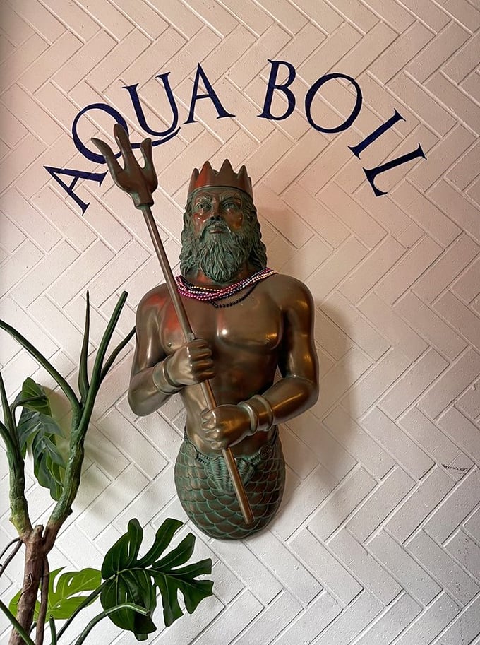 Neptune himself stands guard at Aqua Boil, trident in hand, seemingly approving of the seafood feasts happening in his maritime domain.