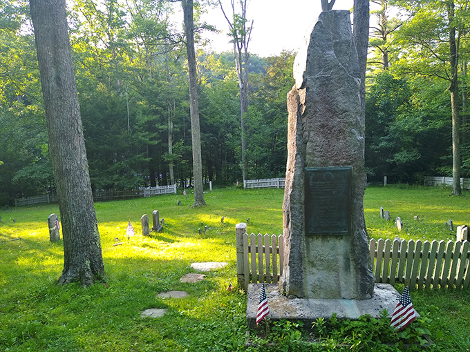 Sunlight dapples through the trees onto history itself. This cemetery monument honors those who lived and worked when Greenwood Furnace roared with industry.
