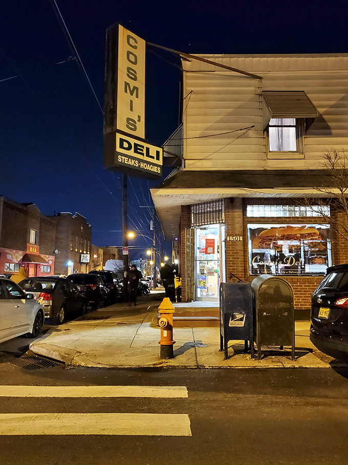By night, the Cosmi's sign glows like a beacon for the hungry. Even after dark, this sandwich sanctuary calls to those in need.