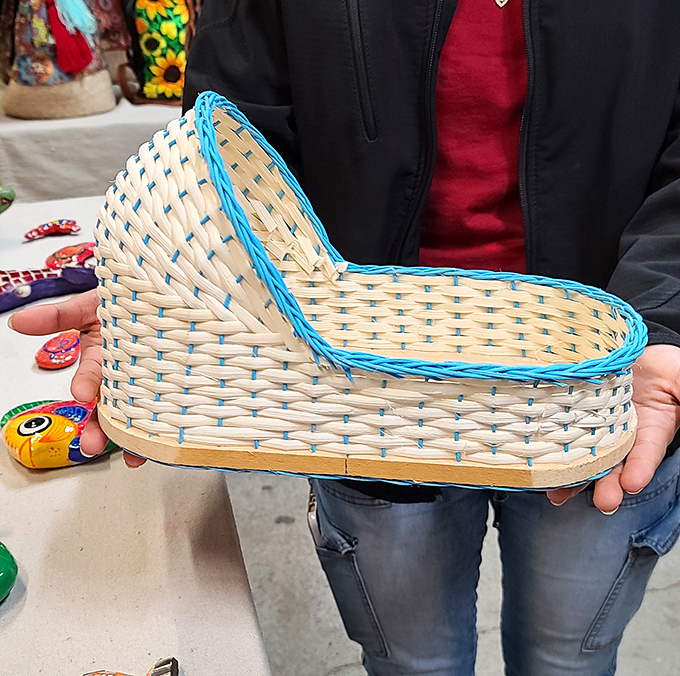 This handcrafted woven bassinet, delicately trimmed in blue, represents the surprising craftsmanship hiding among the market's more commercial offerings.