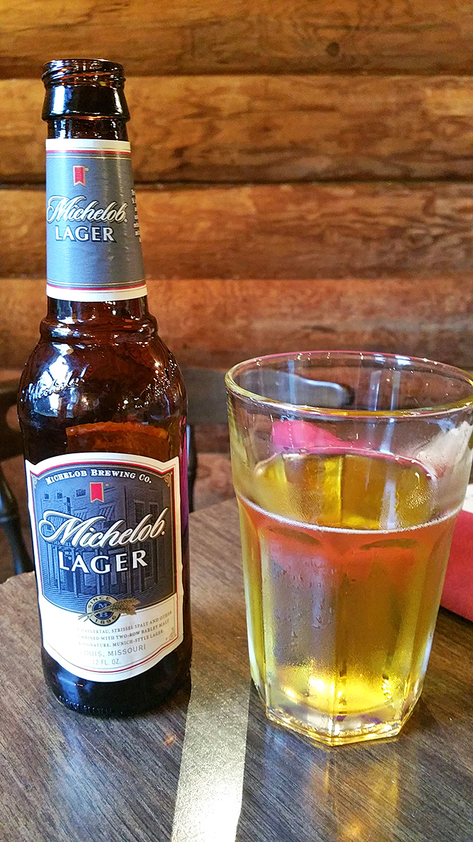 A cold Michelob against rustic wood—because sometimes the perfect barbecue companion isn't fancy, just refreshingly straightforward.