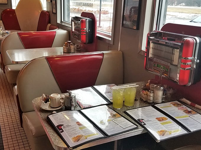 These booths have heard more stories than a bartender. Menus waiting patiently while lemonade sweats in glasses, promising refreshment after a long day.
