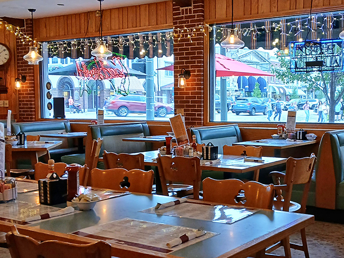 Window booths: prime real estate for people-watching with a side of pancakes. The neon sign's glow adds a touch of diner poetry.