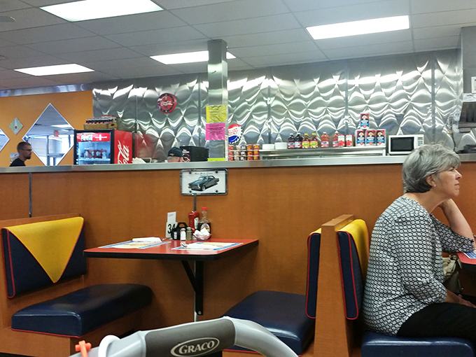 The booth section combines comfort with function&mdash;those metallic wall panels aren't just decorative, they're reflecting decades of satisfied breakfast smiles.