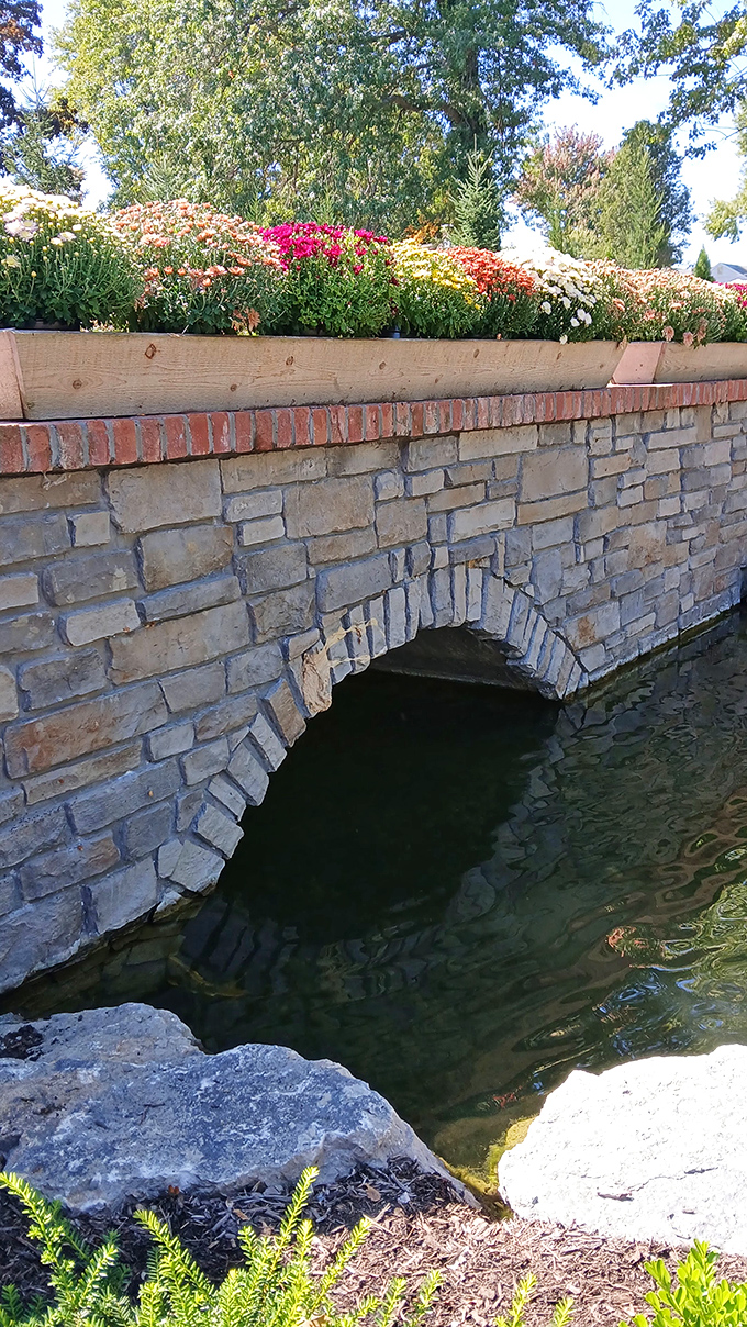 Stone archways cradle flowing water while flowers stand sentinel above&mdash;engineering and horticulture in perfect harmony.