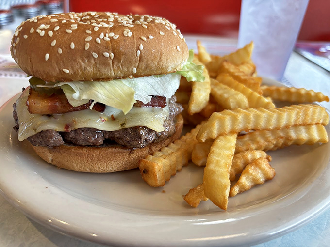 Behold the burger that time forgot &ndash; juicy beef, melty cheese, and bacon stacked on a sesame seed throne, with crinkle-cut fries as loyal subjects.