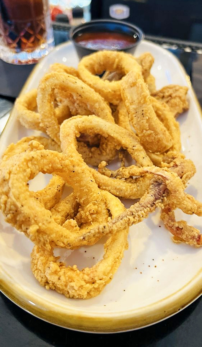 Golden-fried calamari rings that shatter at first bite—proof that even seafood appetizers get the royal treatment at this steakhouse.