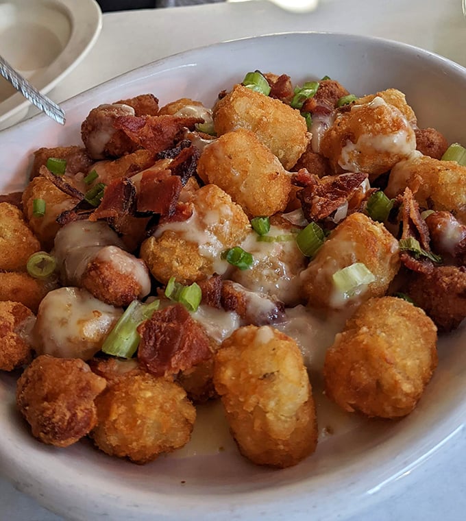 Tater tots living their best life under a blanket of cheese, bacon, and green onions. Comfort food that graduated with honors.