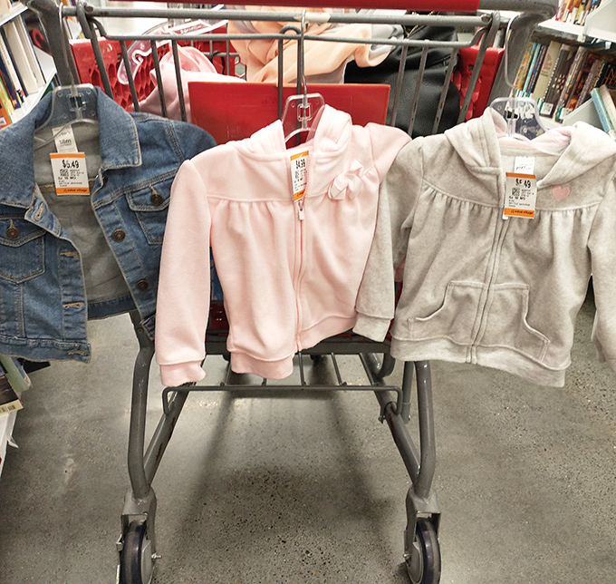 The shopping cart fashion show: where tiny jackets await tiny shoulders and parents discover the economic genius of children's secondhand clothing.
