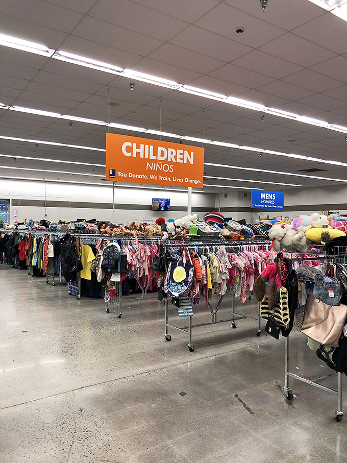 The children's section explodes with color, stuffed animals standing guard over tiny fashion statements below.