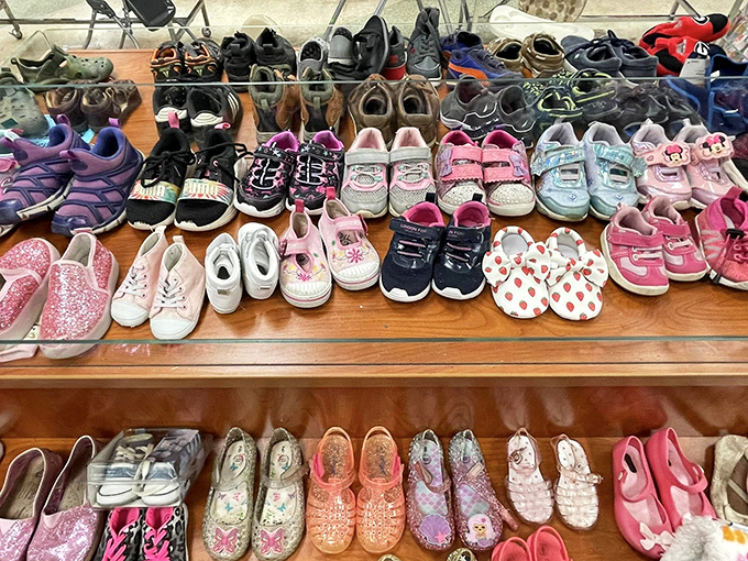 Tiny shoes lined up like colorful soldiers, each pair having supported first steps or playground adventures before awaiting their next small commander.