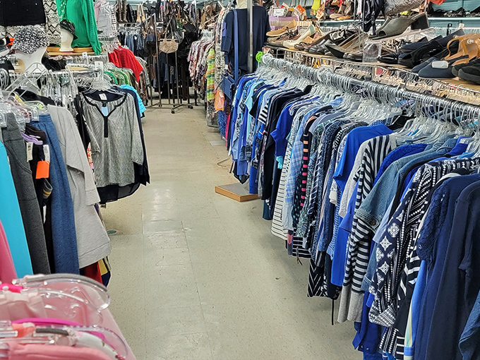 The clothing aisles stretch like a textile rainbow, where yesterday's fashion finds become tomorrow's vintage statement pieces.