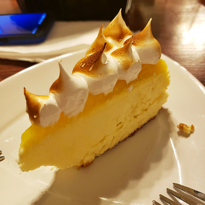 Lemon meringue pie with peaks so perfectly toasted they look like they've spent exactly the right amount of time on a tropical beach.