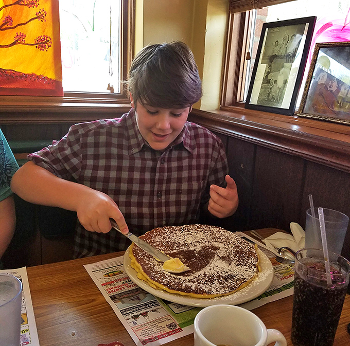 A young diner tackles what appears to be a pancake challenge with determination&mdash;the look of someone who understands the serious business of breakfast.