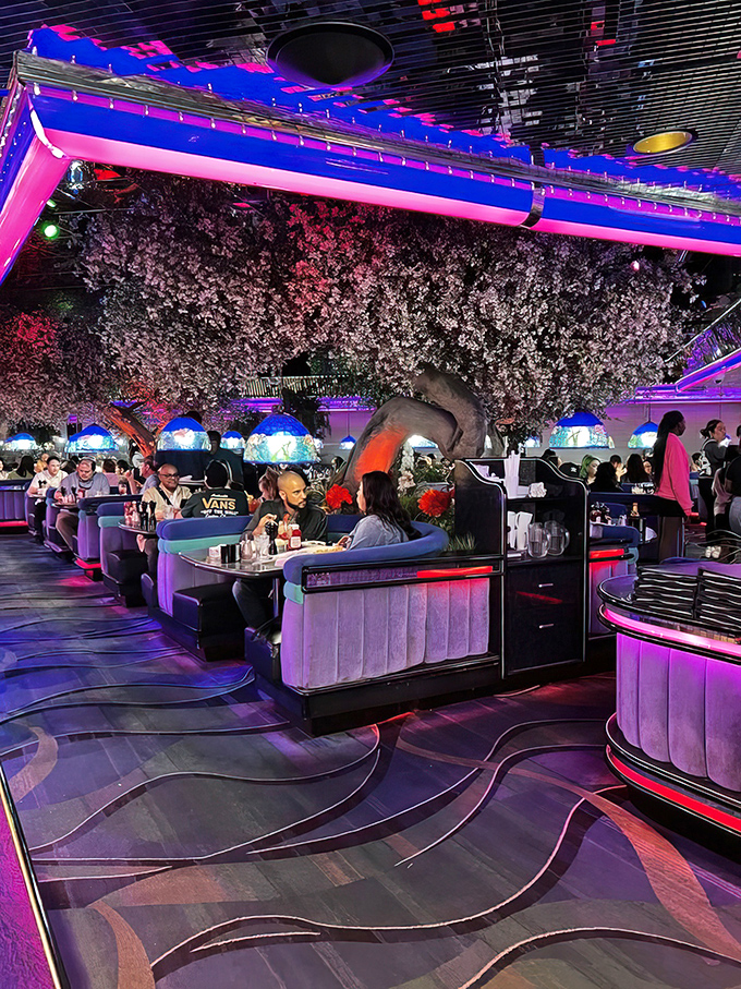 Happy diners surrounded by artificial cherry blossoms prove that sometimes the most joyful meals happen in the most unexpected places.