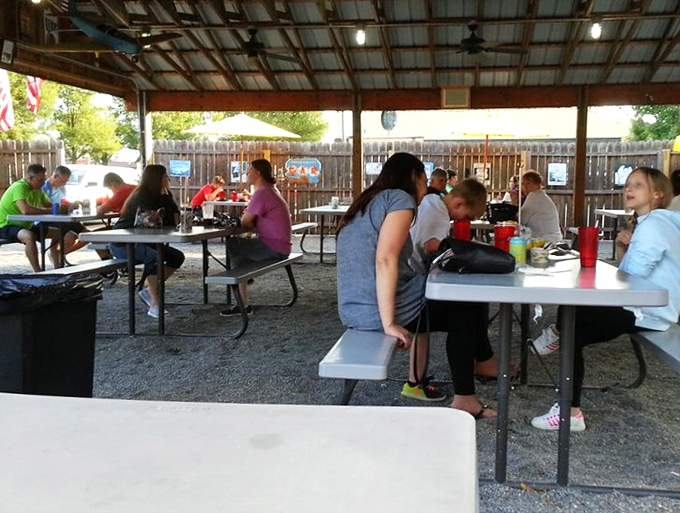 Real people enjoying real barbecue under a pavilion, proving outdoor dining makes everything taste even better somehow.