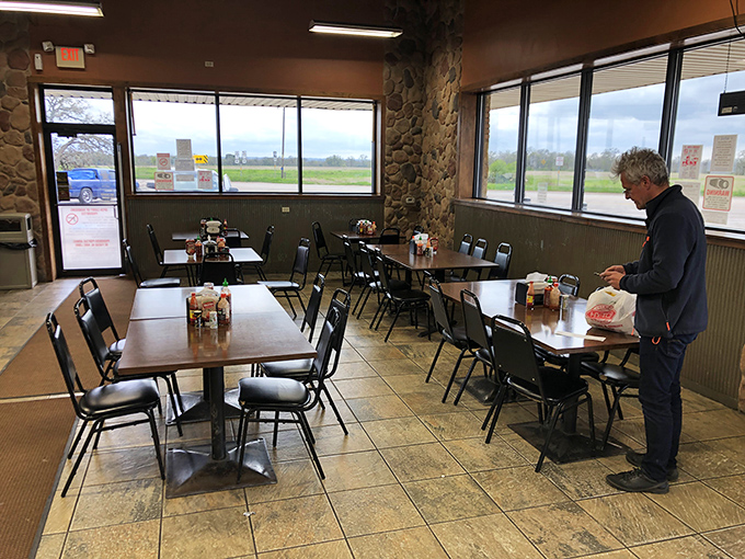 Morning light streams through windows as a lone diner enjoys the quiet ritual of coffee and kolache &ndash; a moment of zen on Highway 71.