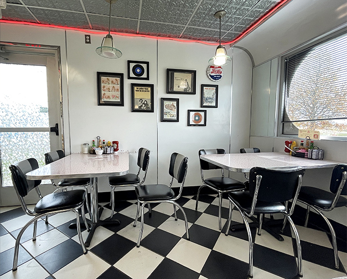 Retro tables and chairs against pristine white walls adorned with vintage memorabilia create the perfect nostalgic dining atmosphere.