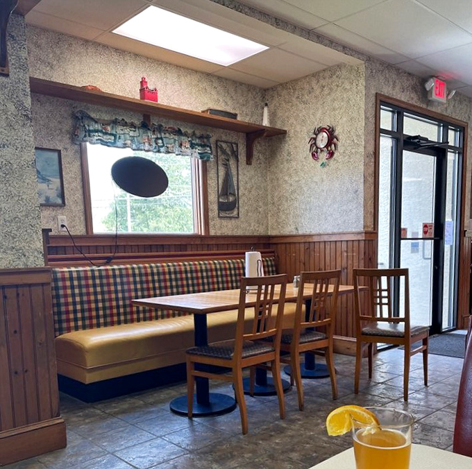 Cozy booth seating with nautical-themed wallpaper offers the perfect spot to linger over local brews and seafood specialties.