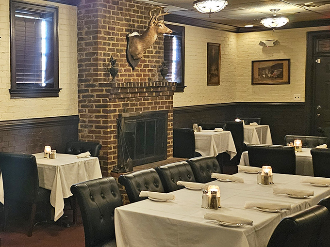 The dining room's exposed brick fireplace adds warmth beyond temperature. Another deer keeps watch, ensuring your steak is cooked exactly as ordered.