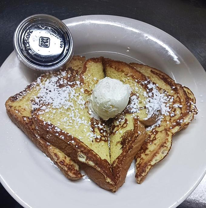 French toast that makes you question all other breakfasts&mdash;golden, custard-soaked perfection crowned with powdered sugar and a scoop of melting butter.