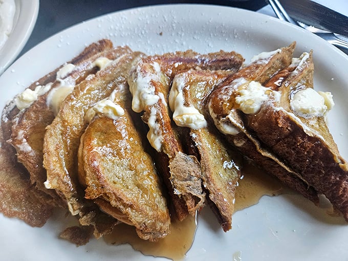 French toast stacked like delicious dominoes, glistening with butter and syrup. Breakfast architecture at its most delicious.