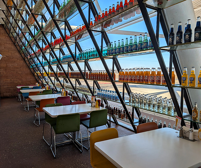 Dining among the bottles creates the curious sensation of eating inside a kaleidoscope, with sunlight filtering through colorful sodas like stained glass.