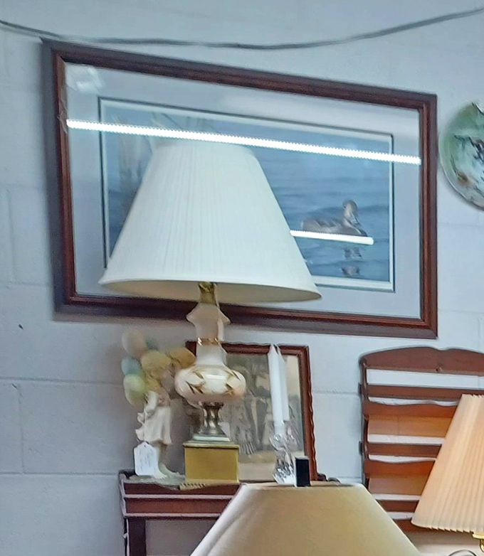 A vintage lamp casts a warm glow beside framed artwork. In the right corner of someone's living room, this could be the star of the show.