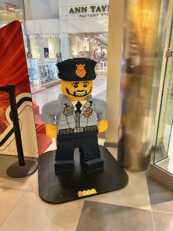 This charming LEGO police officer stands guard near Ann Taylor, proving that even at a serious shopping destination, there's always room for playfulness.