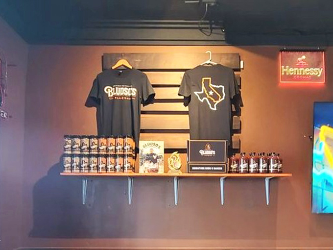 Bludso's merchandise wall—because sometimes wearing the t-shirt is the only way to prove you survived the meat sweats.