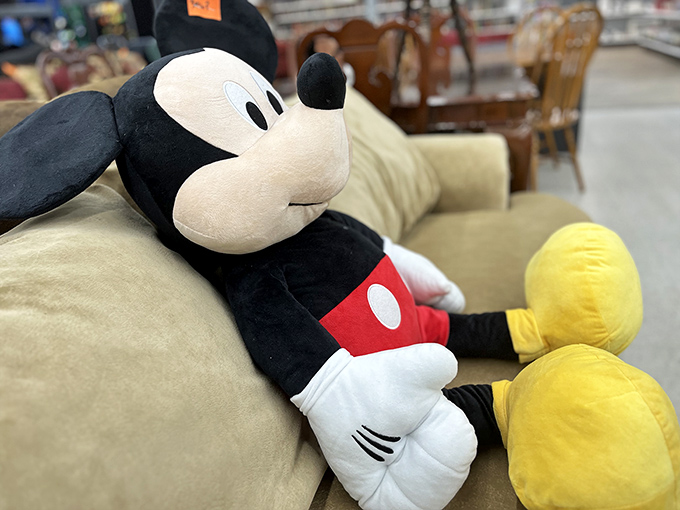 Mickey Mouse lounges casually on a beige sofa, looking like he's taking a well-deserved break from entertaining generations of children.