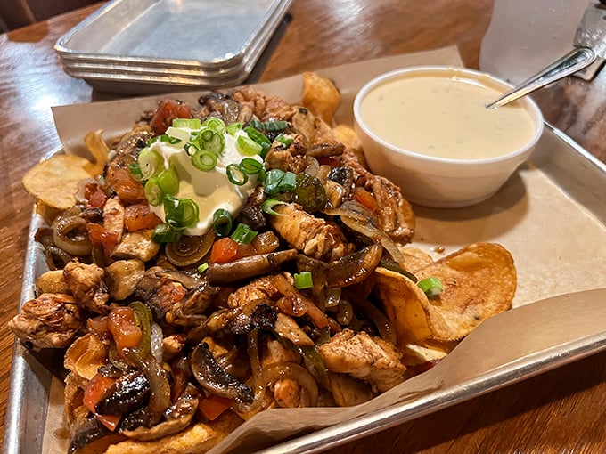 Nachos that laugh in the face of restraint. This mountain of toppings, cheese, and chicken is what happens when "a little extra" goes wild.