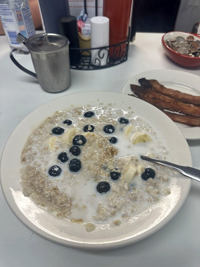 Oatmeal elevated from punishment to pleasure with blueberries standing by like tasty little sentinels. Those bacon strips aren't just sides &ndash; they're essential companions.