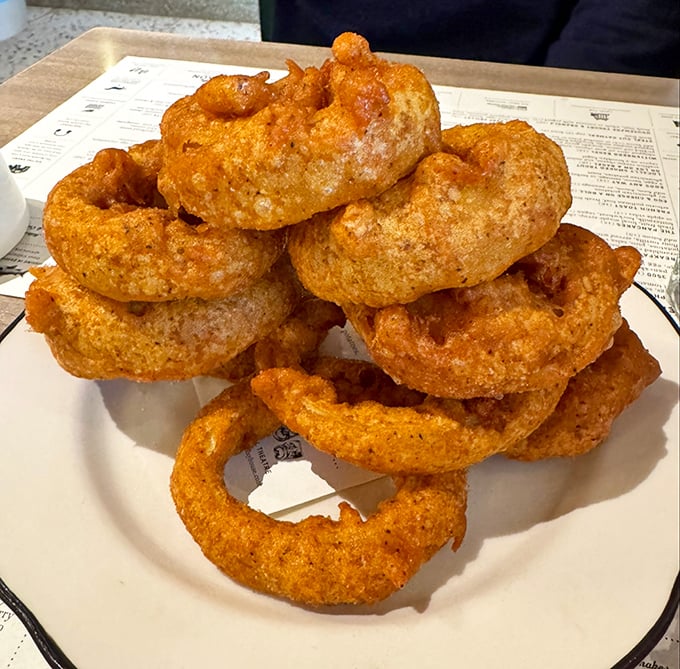 Onion rings stacked higher than my last credit card bill, with a golden crunch that announces itself from three tables away.