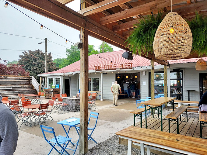 Michigan summer perfection: wooden beams, hanging plants, and tables arranged for both intimate conversations and chance encounters with fellow food lovers.
