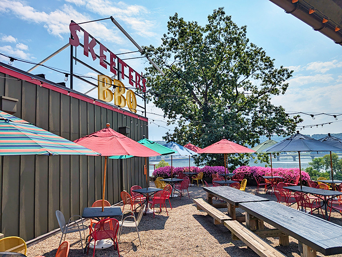 Outdoor seating with colorful umbrellas and a river view&mdash;because BBQ tastes even better with a side of sunshine and gentle breezes.