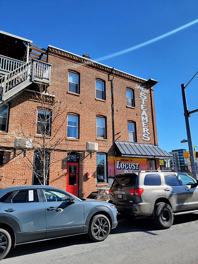 The unassuming brick exterior hides seafood treasures within, while the rooftop deck (just visible up those stairs) offers harbor views with your crab feast.