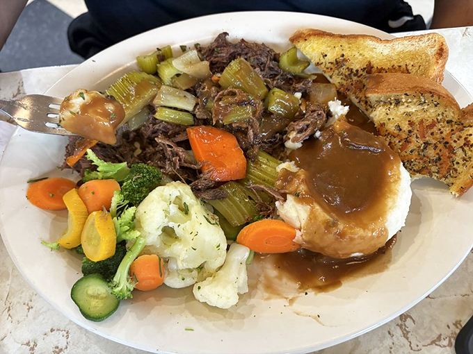 Pot roast that's clearly been on speaking terms with those vegetables for hours. That gravy has stories to tell.