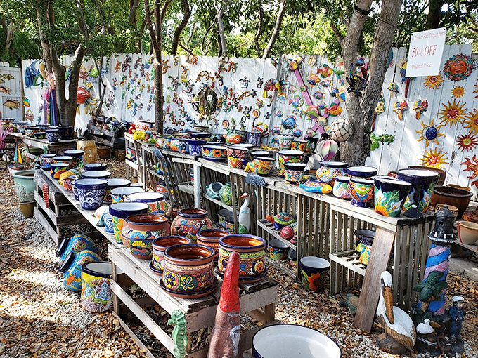 A rainbow explosion of handcrafted pottery lines weathered wooden shelves. Each piece tells a story of sun, salt, and the artistic spirit of the Keys.