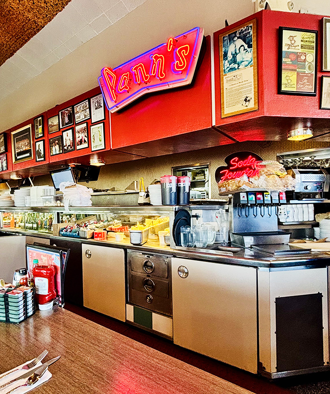 Neon signs illuminate the prep area, a shrine to American diner culture. Where milkshakes are born and diet plans go to die.