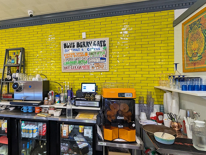 The vibrant yellow brick wall and handwritten menu board create a sunny backdrop for coffee magic that happens at this bustling prep station.