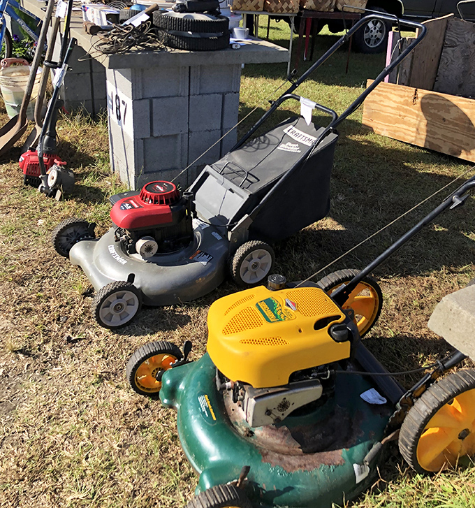 Lawn mowers with stories to tell&mdash;the red one probably cut the grass at three different houses before landing at stall 107.