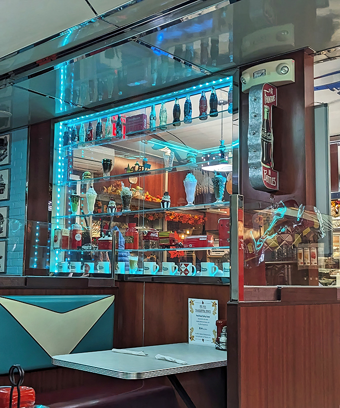 The display case glows with nostalgic treasures. Each bottle and vintage collectible tells a story of American dining history.