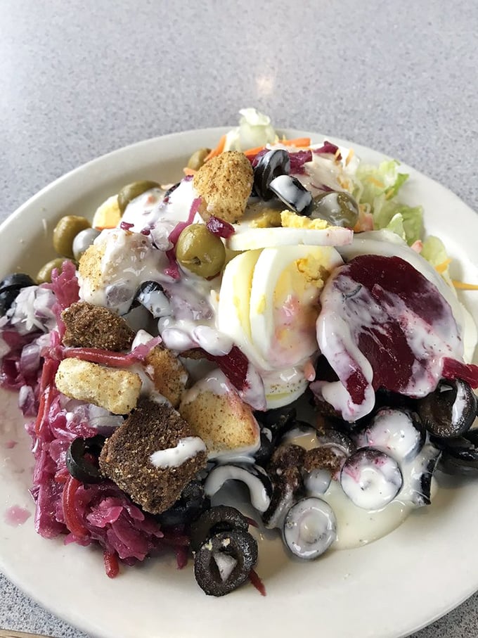This isn't just a salad&mdash;it's a colorful neighborhood where olives, eggs, and croutons live in perfect harmony under a creamy sky.