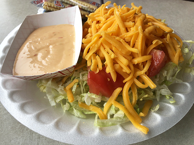 A simple side salad topped with shredded cheddar&mdash;because sometimes you need something green before diving into burger paradise.