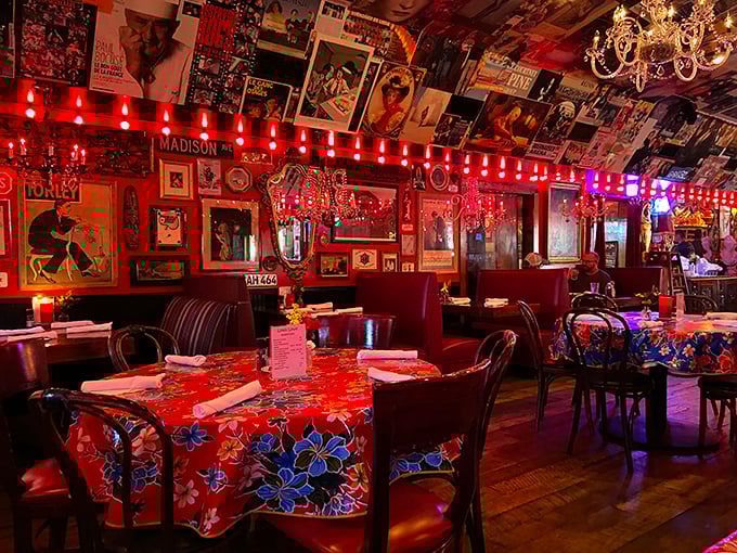 Red booths and vibrant tablecloths create the kind of dining room where conversations flow as easily as the drinks, under the watchful gaze of vintage posters.