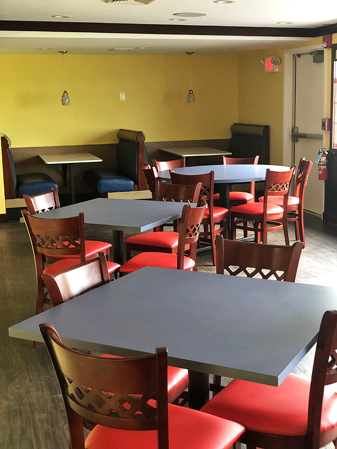 Cheerful yellow walls and cherry-red chairs create a dining room that feels like happiness decided to open a restaurant.